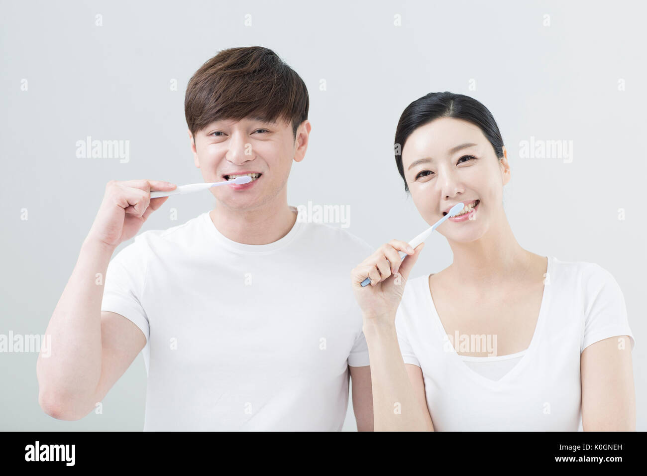 Portrait of smiling couple brushing their teeth Stock Photo - Alamy