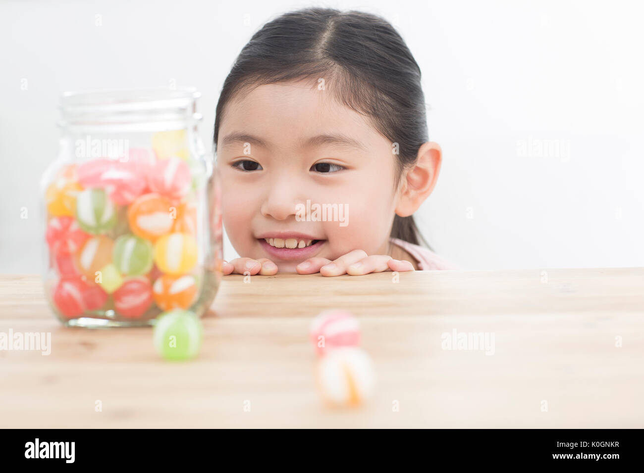 Po of smiling girl watching candies in a jar Stock Photo - Alamy
