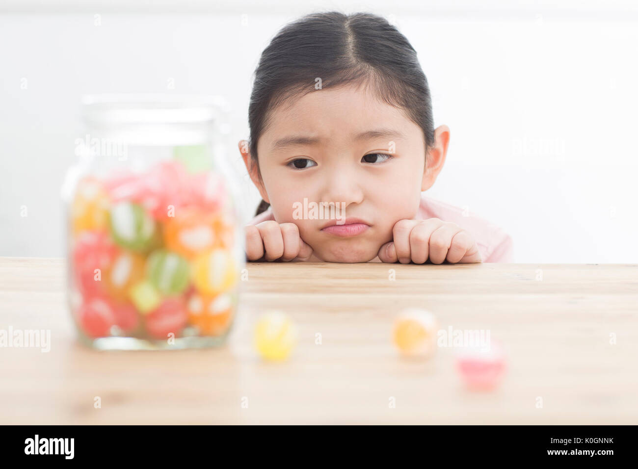 Portrait of girl watching candies in a jar Stock Photo - Alamy