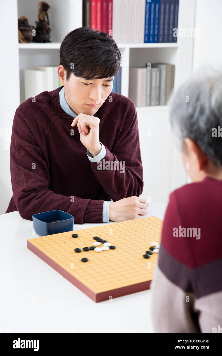 Portrait of young man and his senior father playing go Stock Photo - Alamy