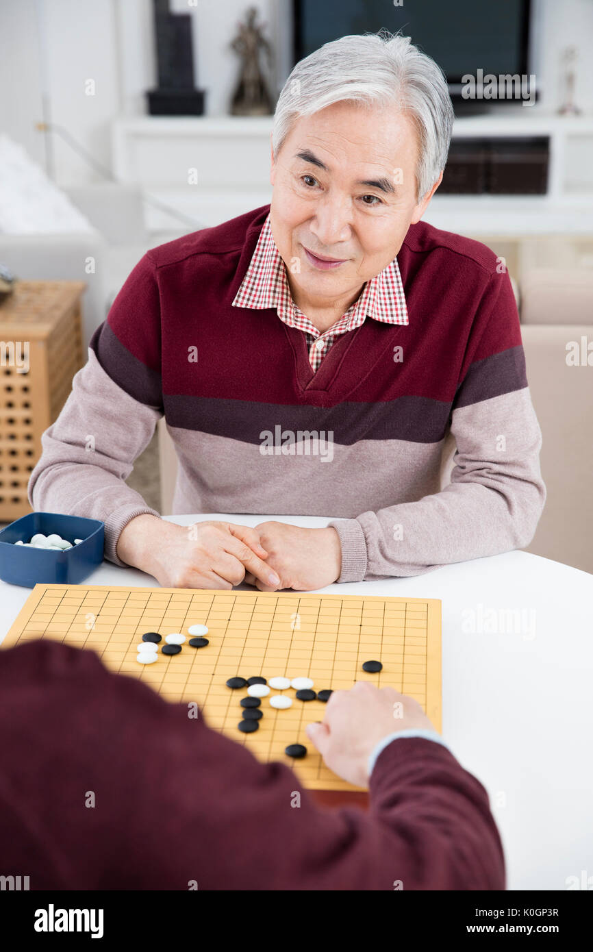 Portrait of smiling senior man and his son playing go Stock Photo - Alamy