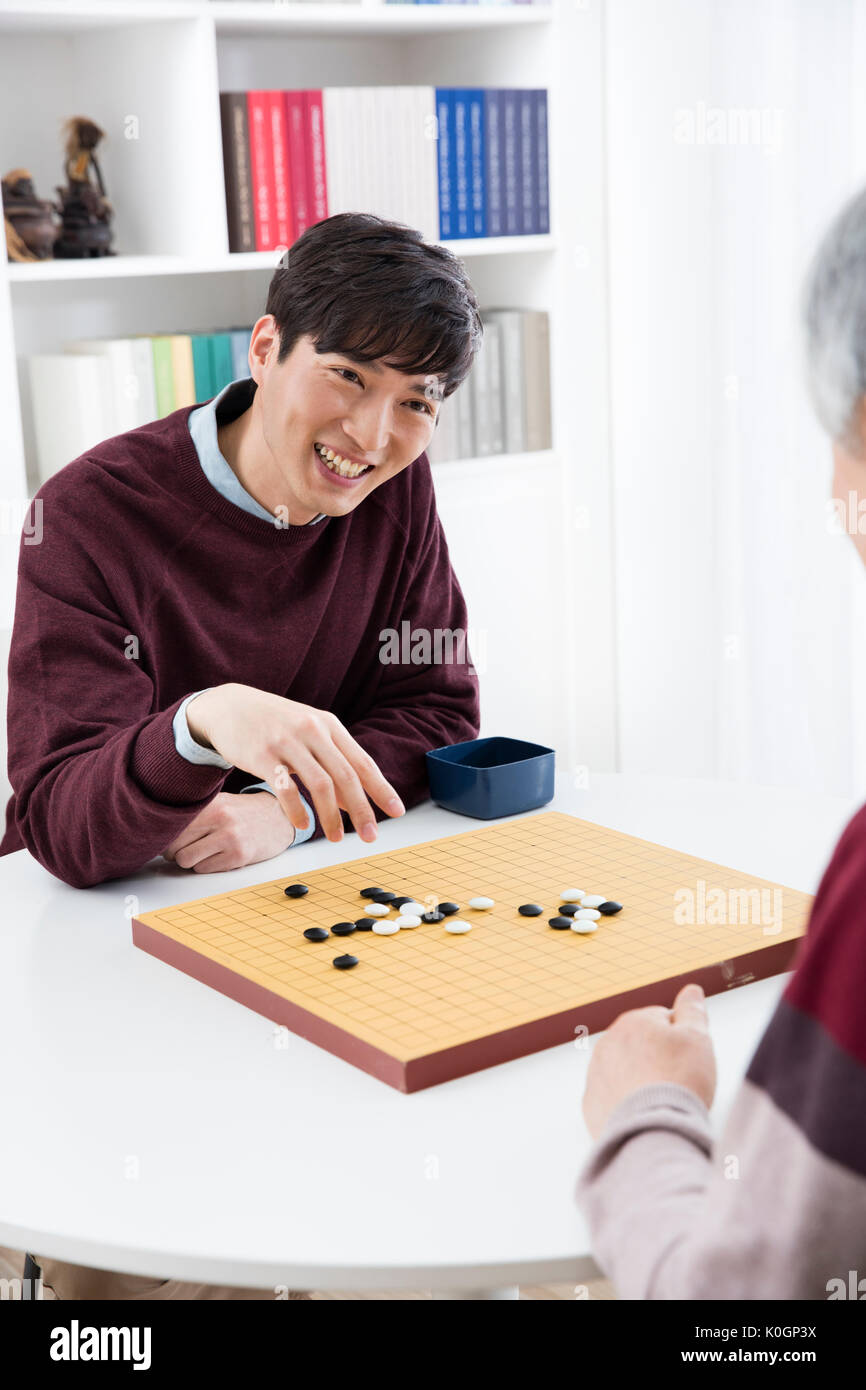 Portrait of young smiling man and his father playing go Stock Photo - Alamy
