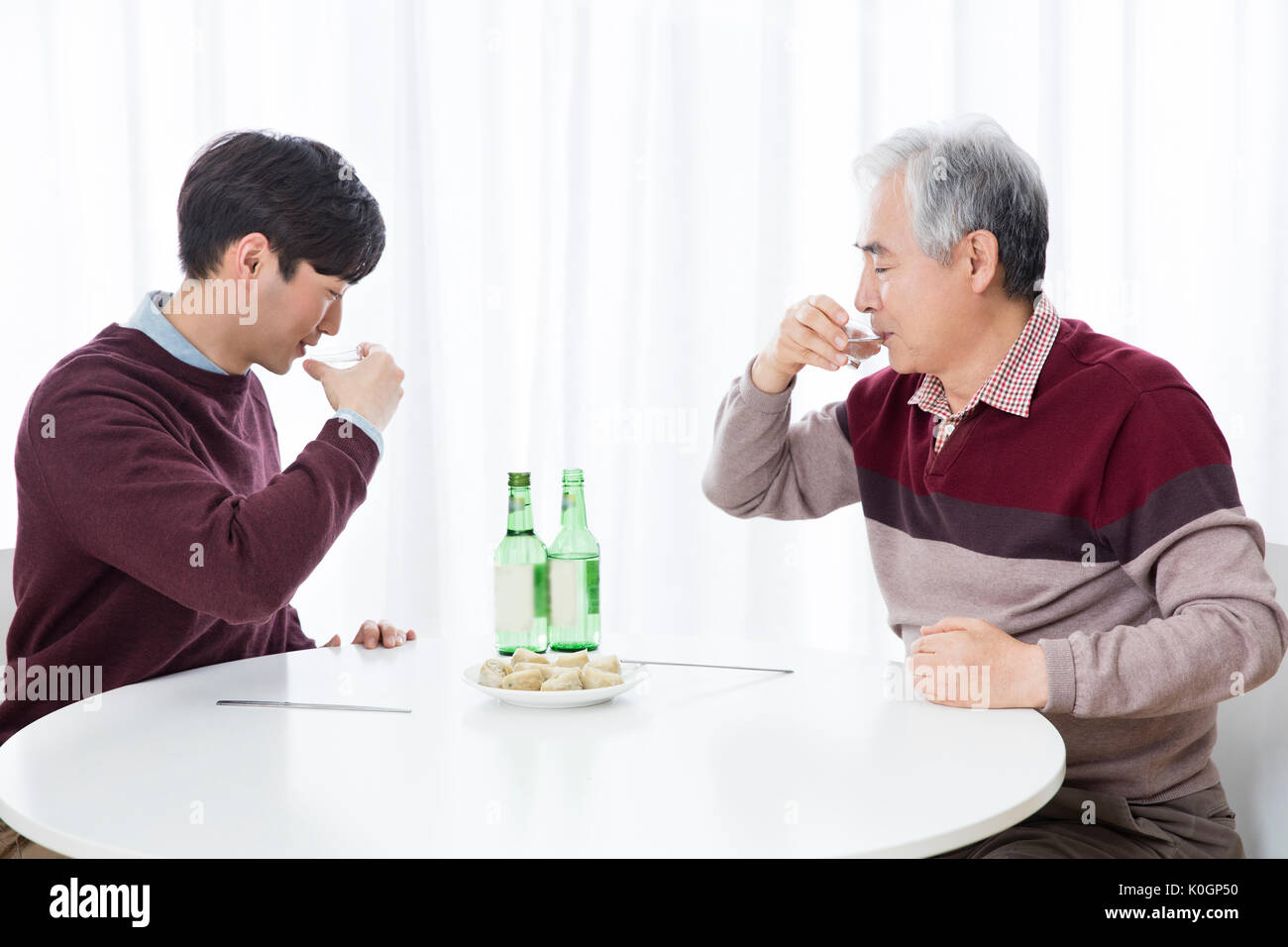 Portrait of young man and his senior father drinking Stock Photo - Alamy