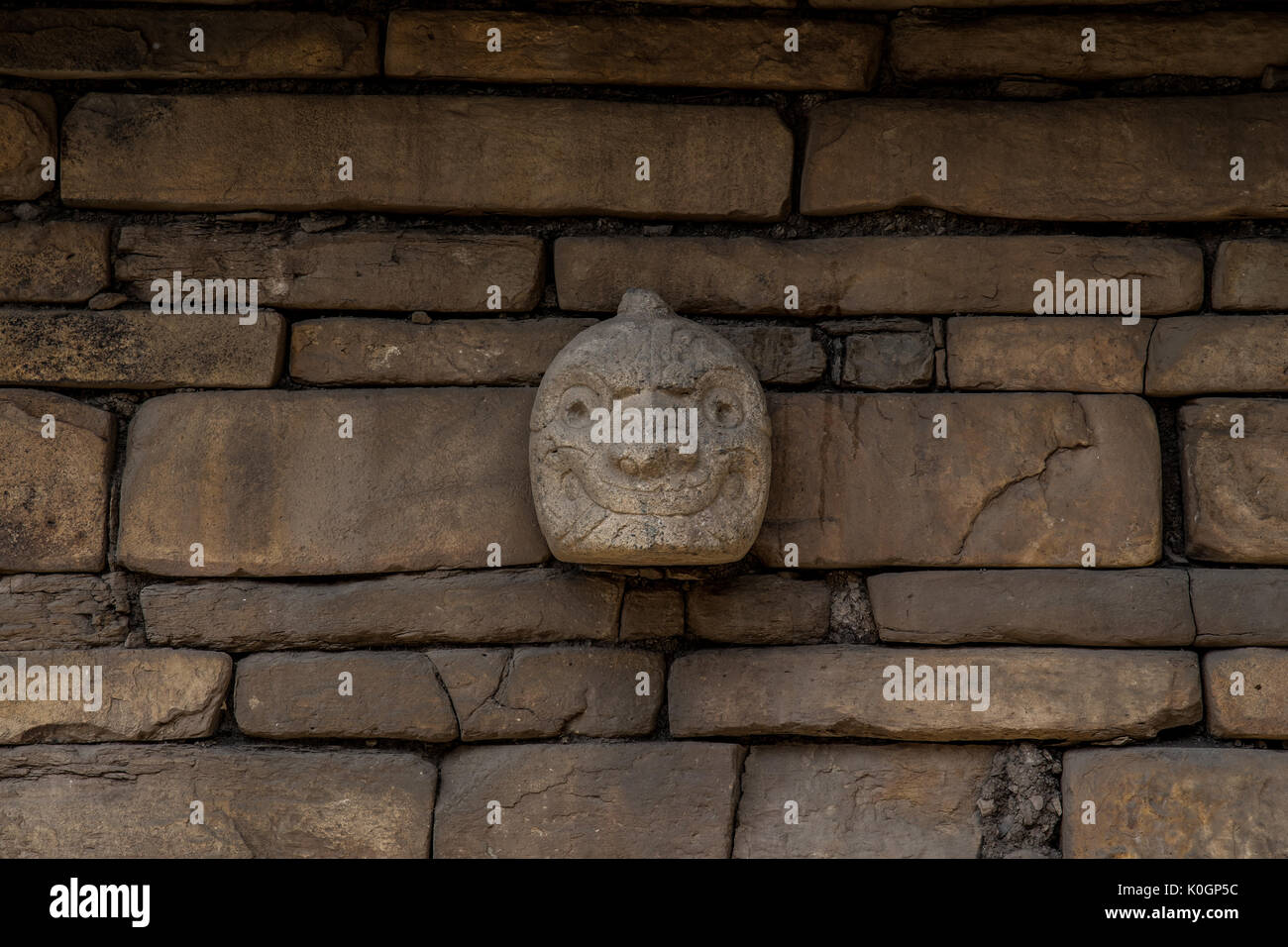 A stone head upon a stone wall in the historic ruins of Chavin de ...