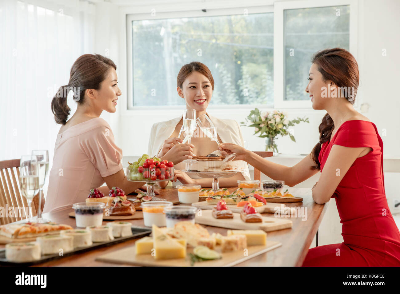 Three young smiling women celebrating at party Stock Photo - Alamy