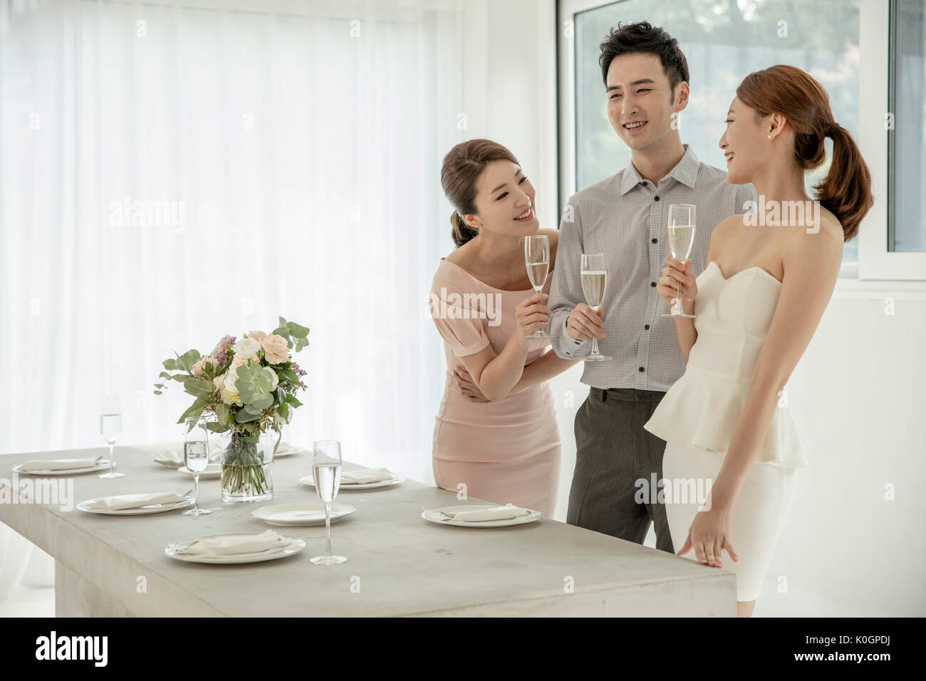 Three young smiling friends with champagne enjoying a party Stock Photo ...