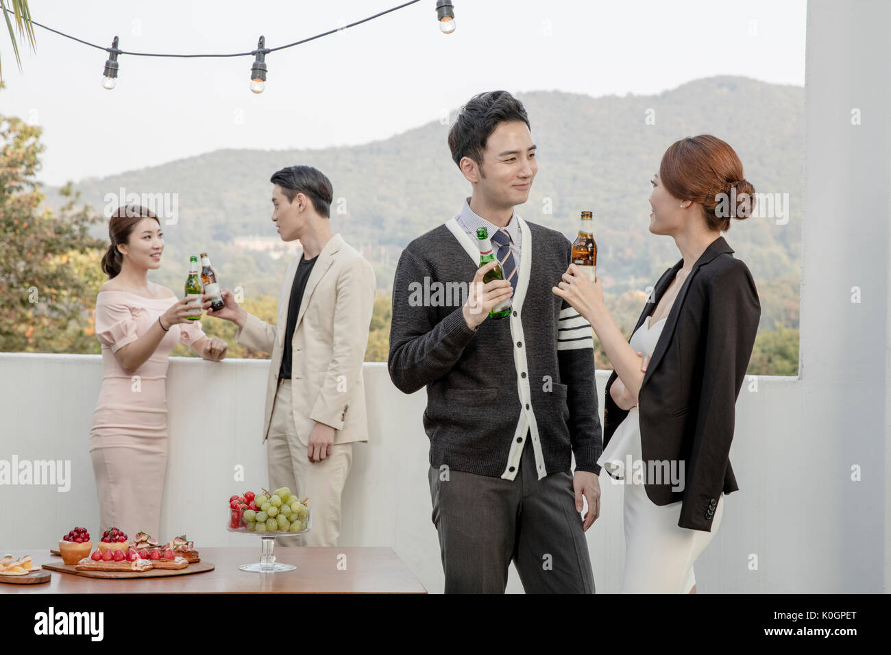 Young smiling friends having talks at party on rooftop Stock Photo - Alamy