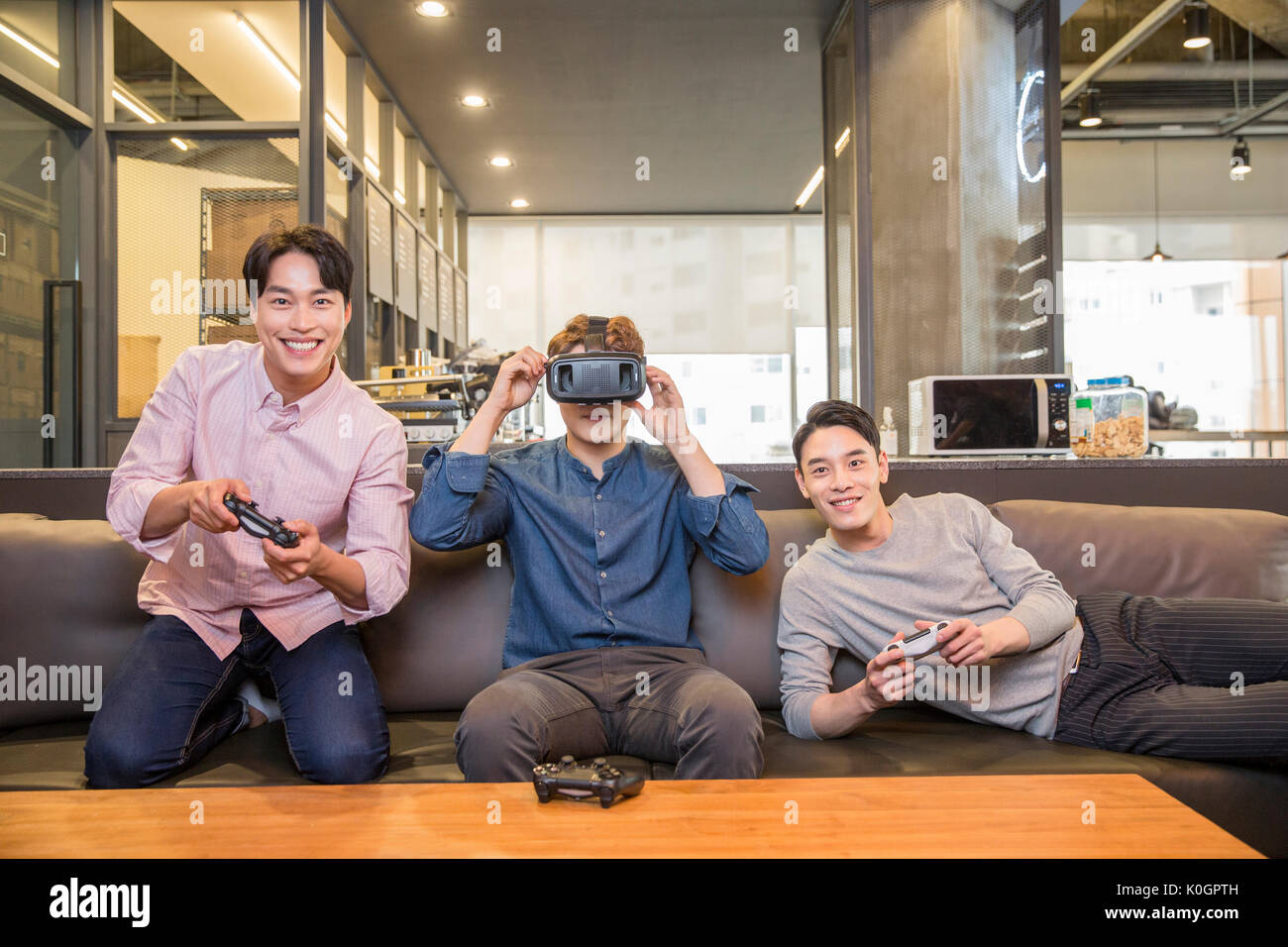 Three smiling businessmen enjoying virtual reality games Stock Photo ...