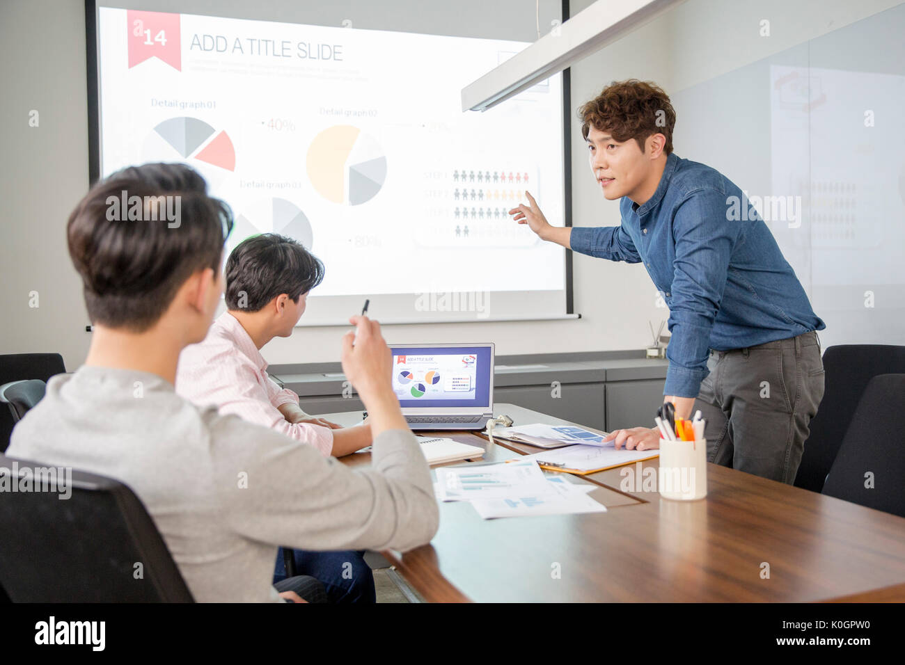 Three businessmen having a presentation Stock Photo - Alamy