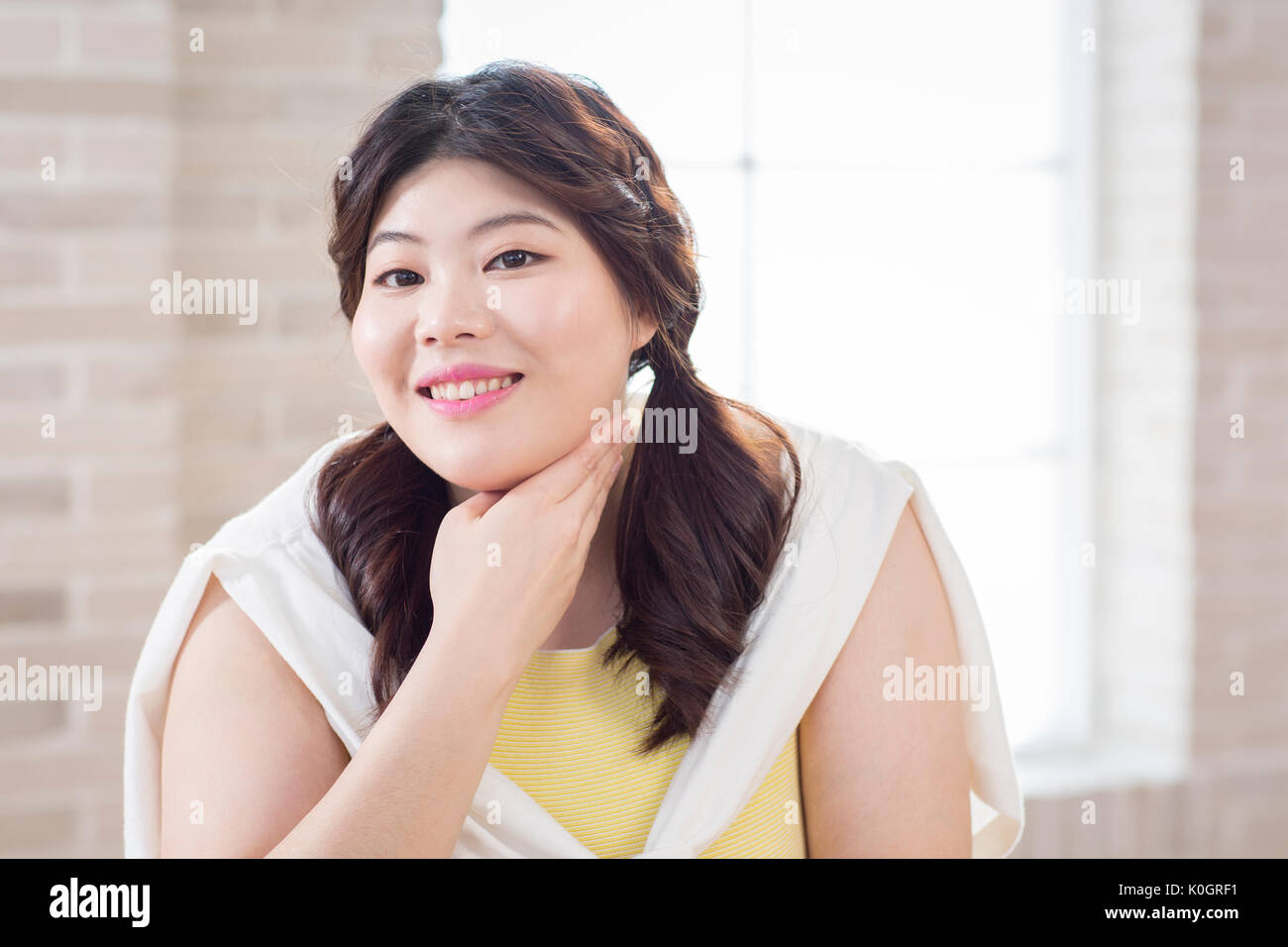Portrait of young smiling fat woman touching her face Stock Photo - Alamy