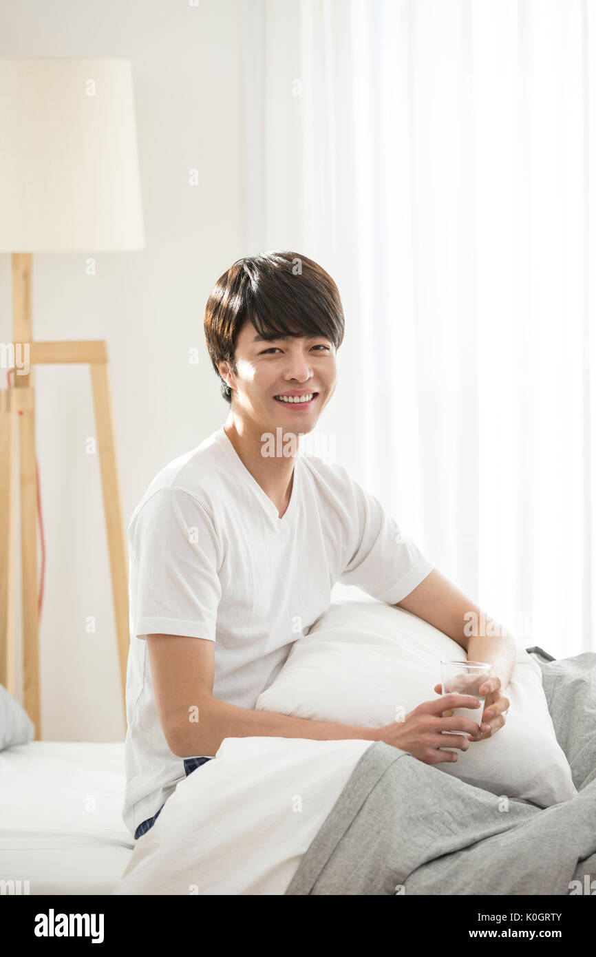 Portrait of single man sitting in bed Stock Photo - Alamy