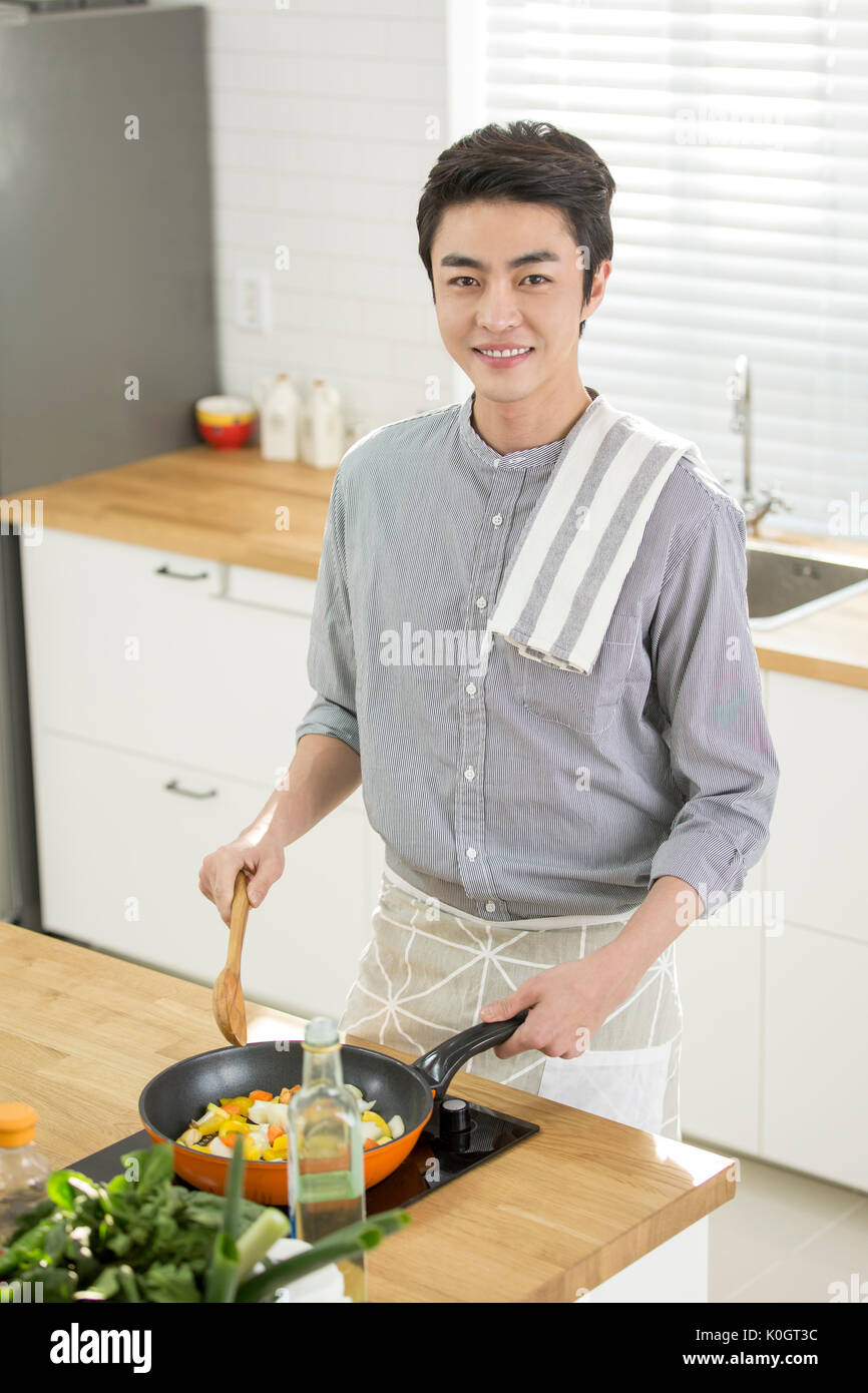 Smiling single man cooking Stock Photo - Alamy