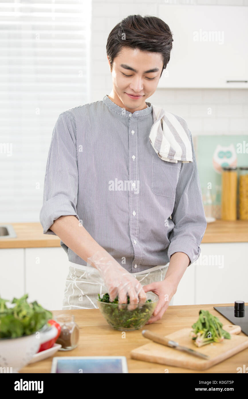 Smiling single man making food Stock Photo - Alamy