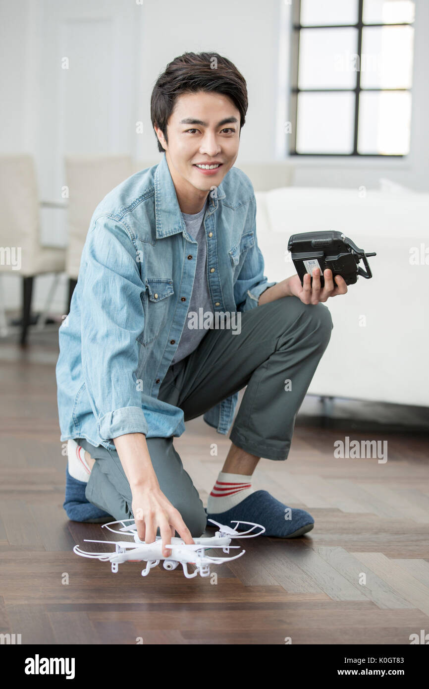 Smiling male kidult playing with drone Stock Photo - Alamy