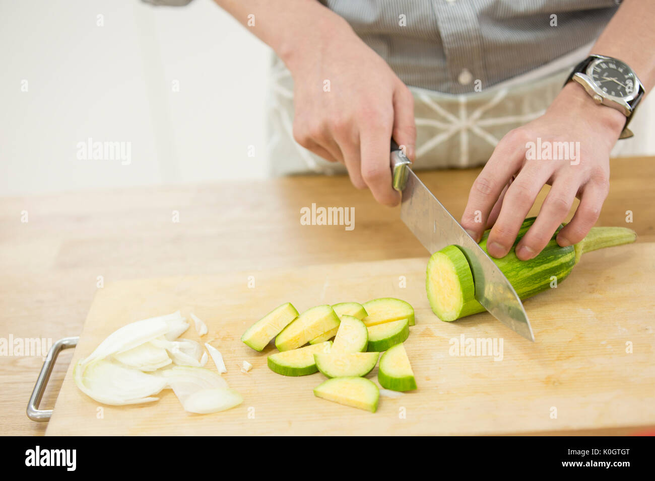 Single man cutting vegetable with kitchen knife on chopping board Stock ...