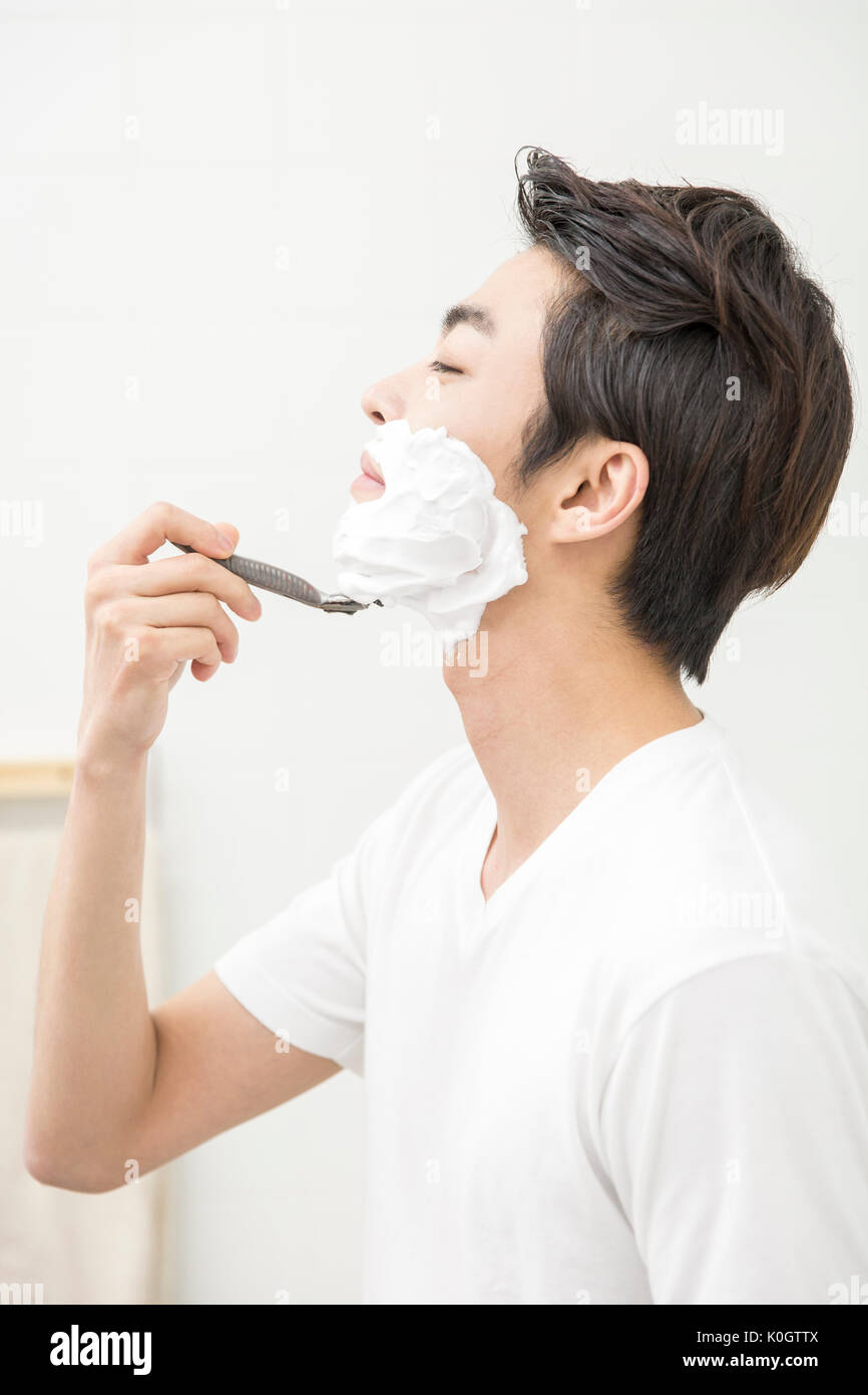Side view of grooming shaving his face Stock Photo - Alamy