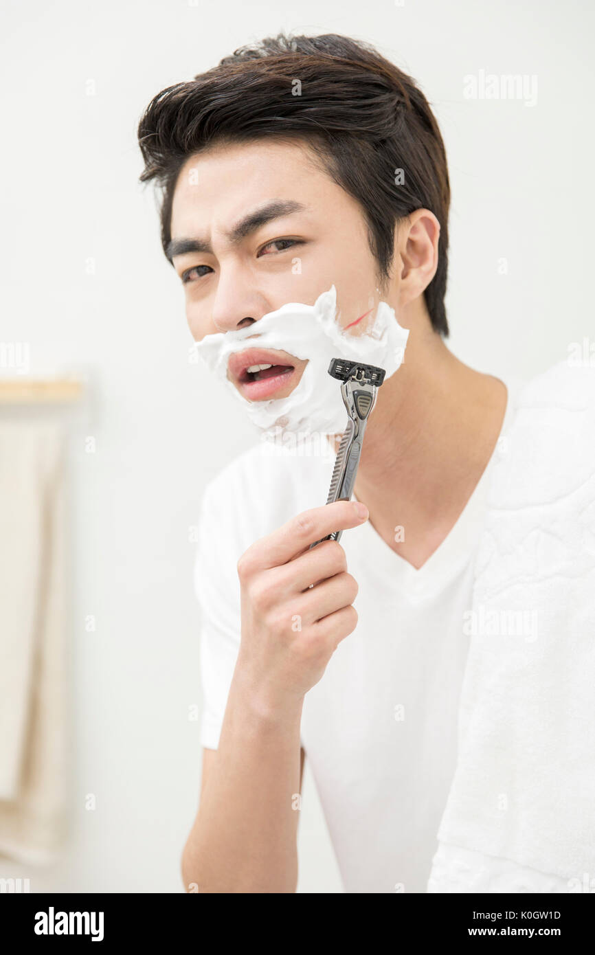 Portrait of grooming hurting his face during shaving Stock Photo - Alamy