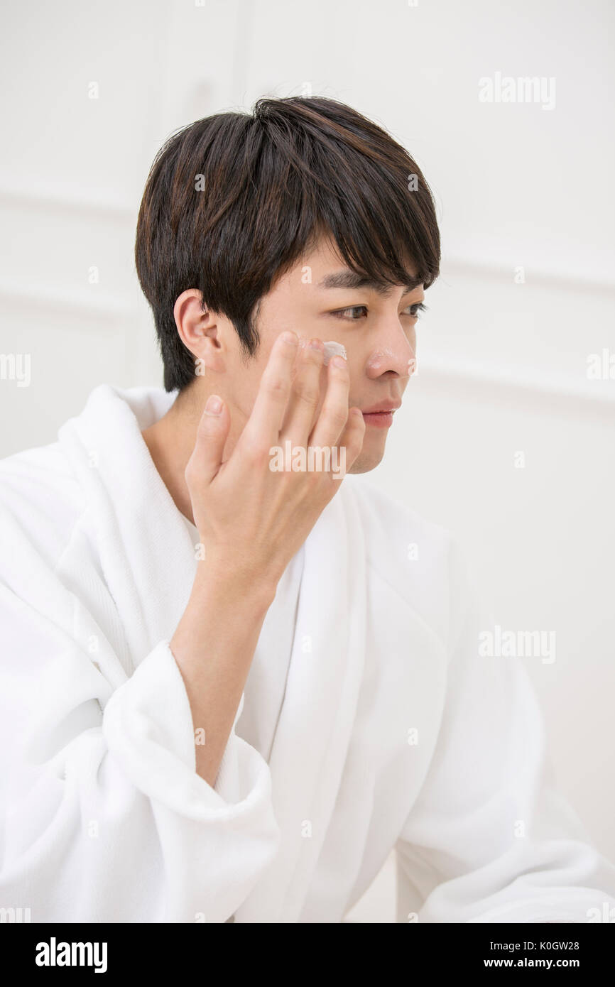 Portrait of grooming putting on cosmetic on his face Stock Photo - Alamy