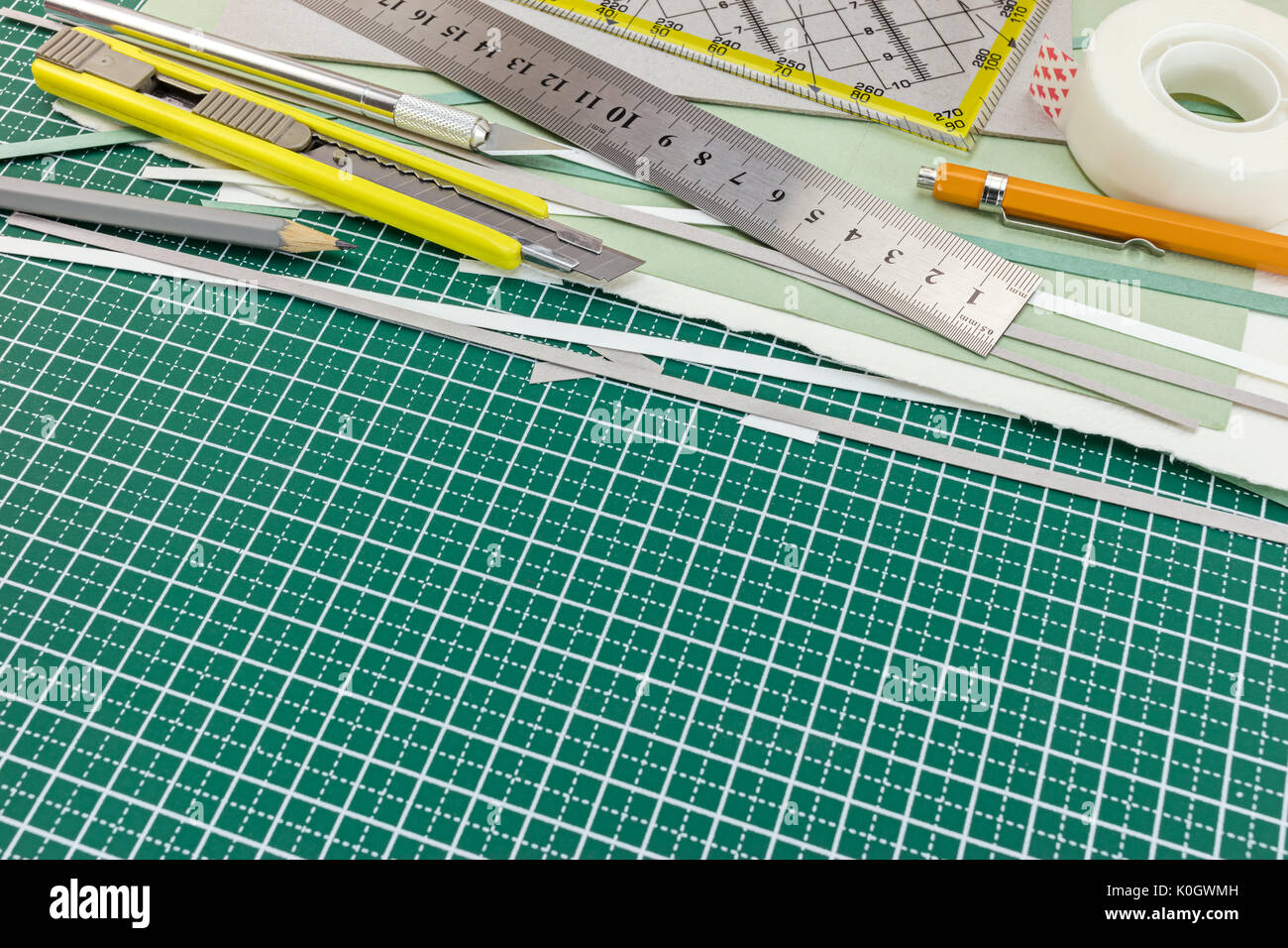 office workplace with various supplies and work tools on green cutting ...