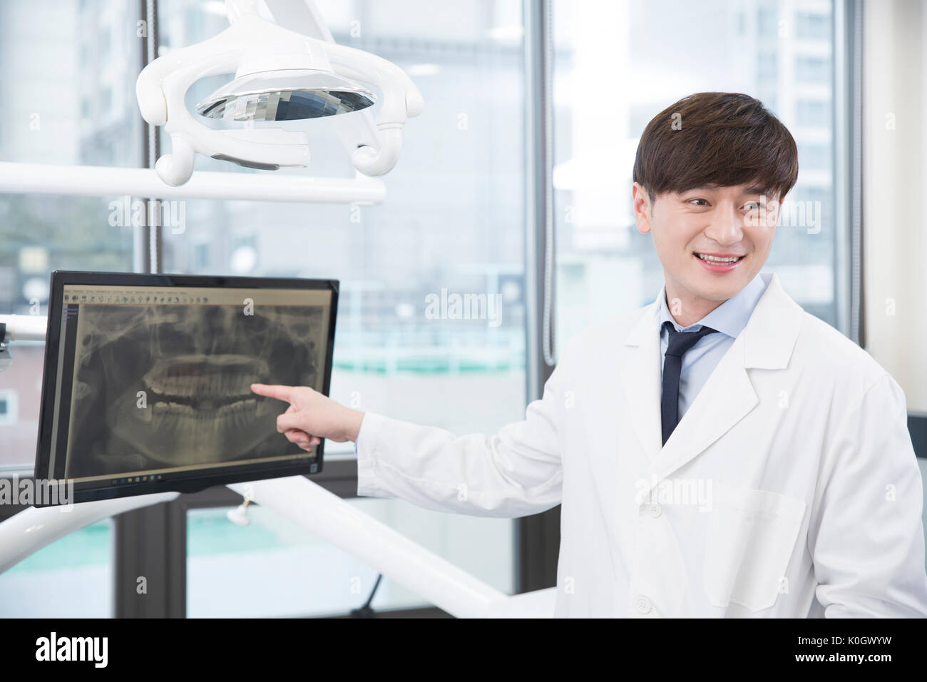 Smiling dentist pointing at an x-ray picture Stock Photo - Alamy