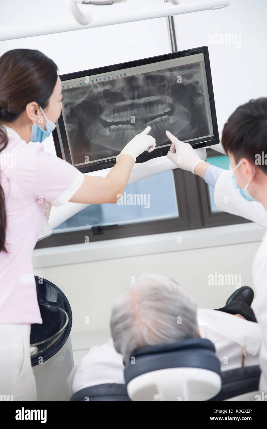 Dental hygienist and dentist showing x-ray picture to a patient Stock ...