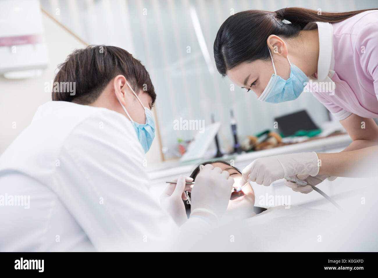 Dentist and dental hygienist curing a patient Stock Photo - Alamy