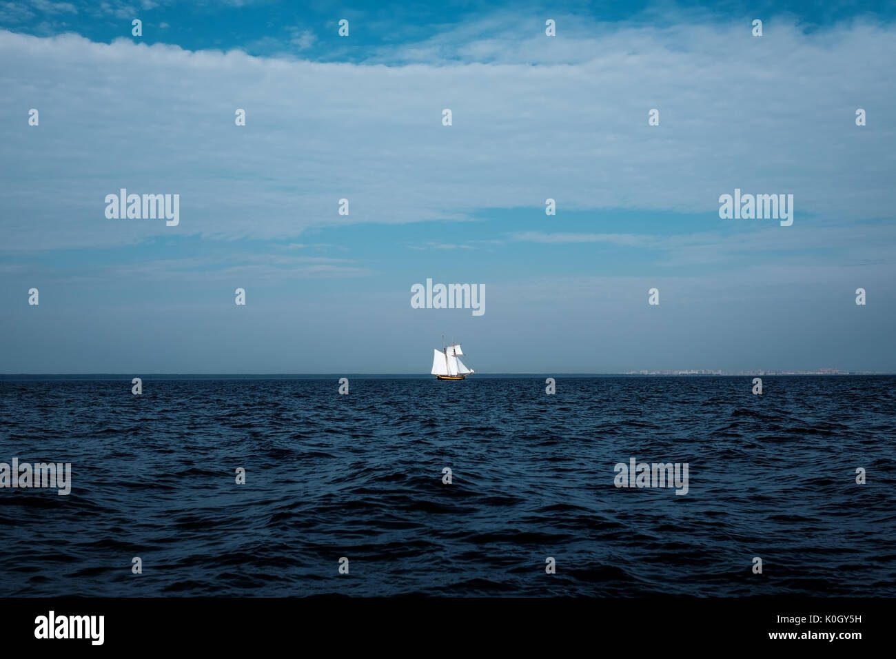 Dramatic seascape with small white yacht far away. Dark sea water Stock ...