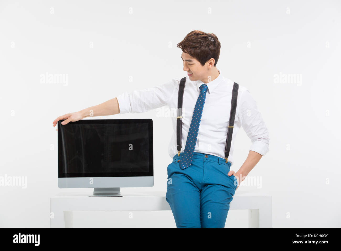 Young smiling businessman touching a computer monitor Stock Photo - Alamy