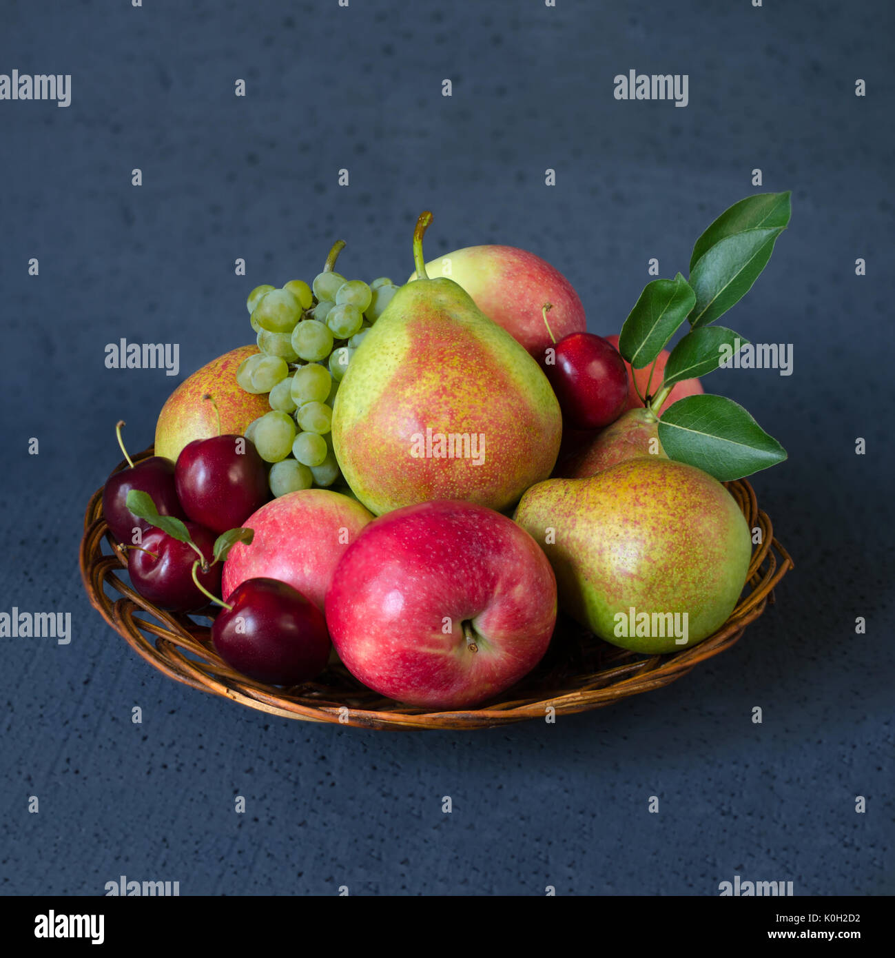 Autumn fruit mix - fresh apples, pears, grapes and plums in a wicker ...