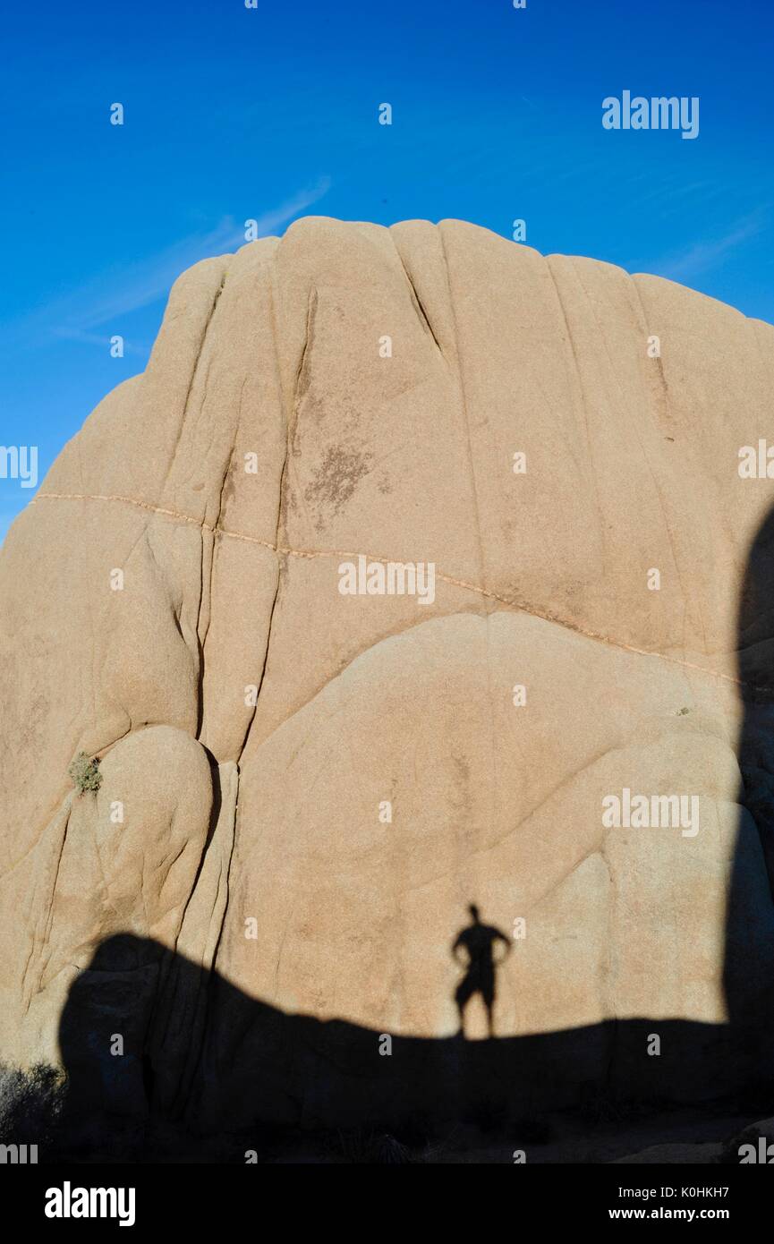 Shadow of single hiker on monzogranite rock formation boulder in Joshua ...