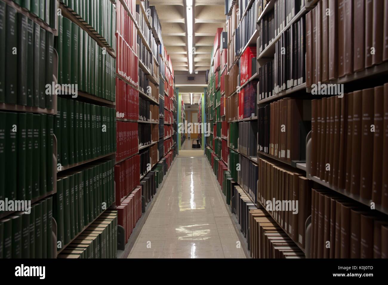 A photograph looking down the stacks of the library, 2014. Courtesy ...
