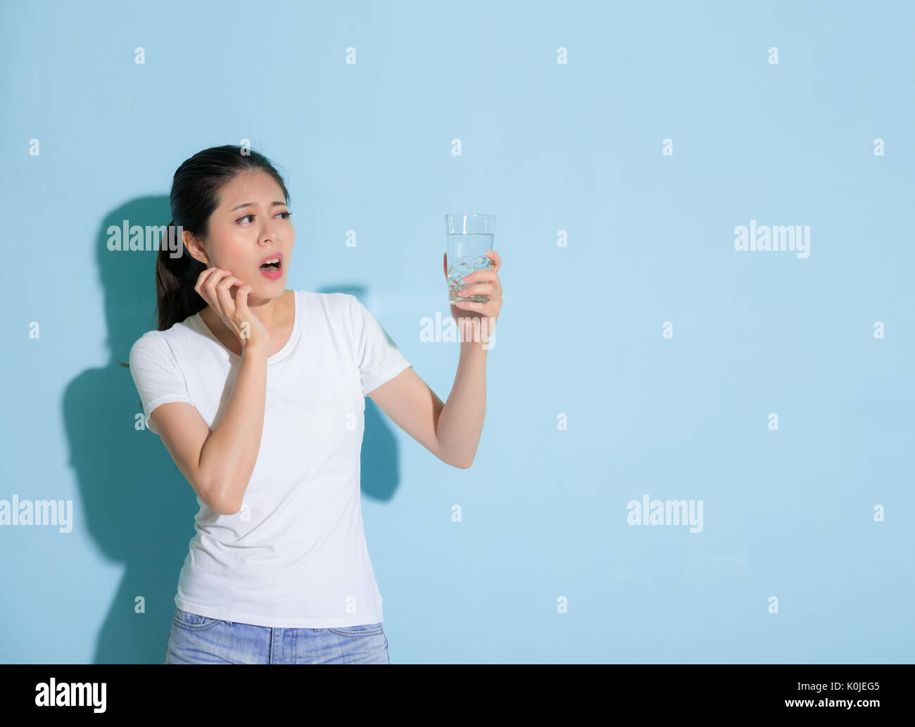 cute sweet girl looking at ice water worry about sensitive teeth attack ...
