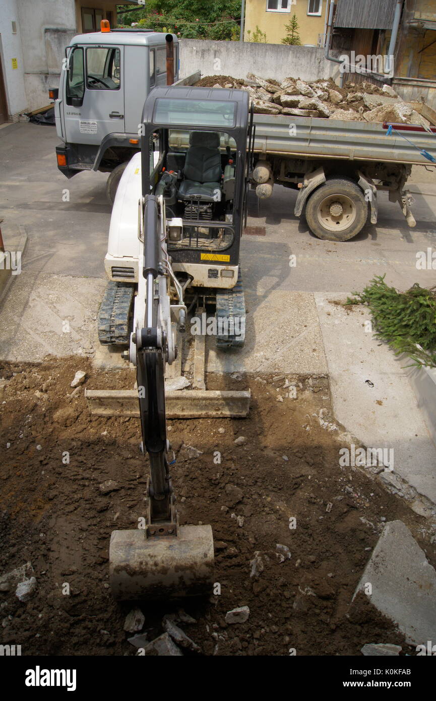 Bulldozer digging in the yard and truck waiting to transport Stock ...