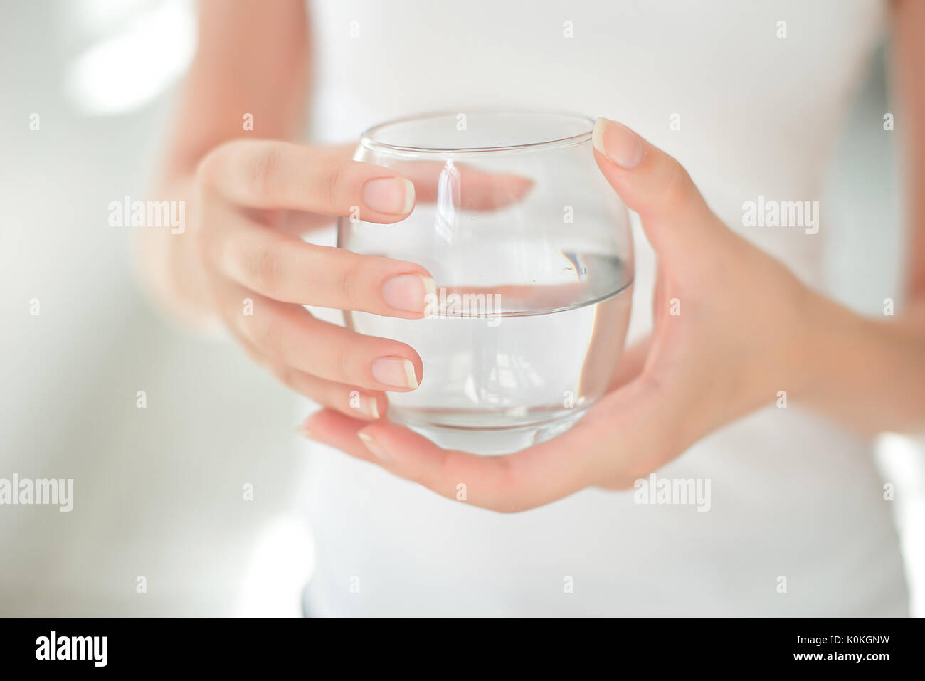 Female handa holding a clear glass of water. Slime body on background ...