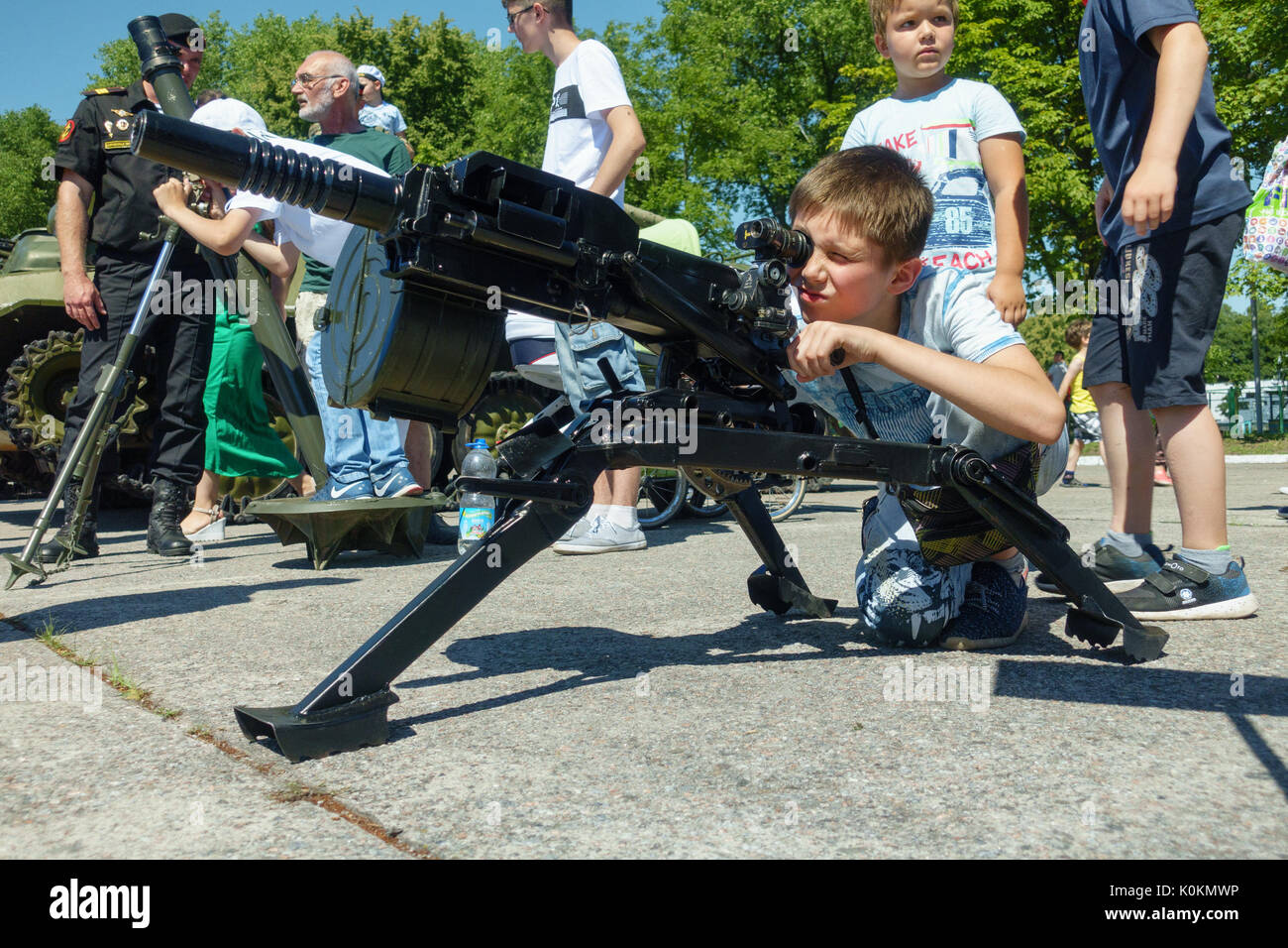 Unidentified children age 5-10 years try real weapons Stock Photo - Alamy
