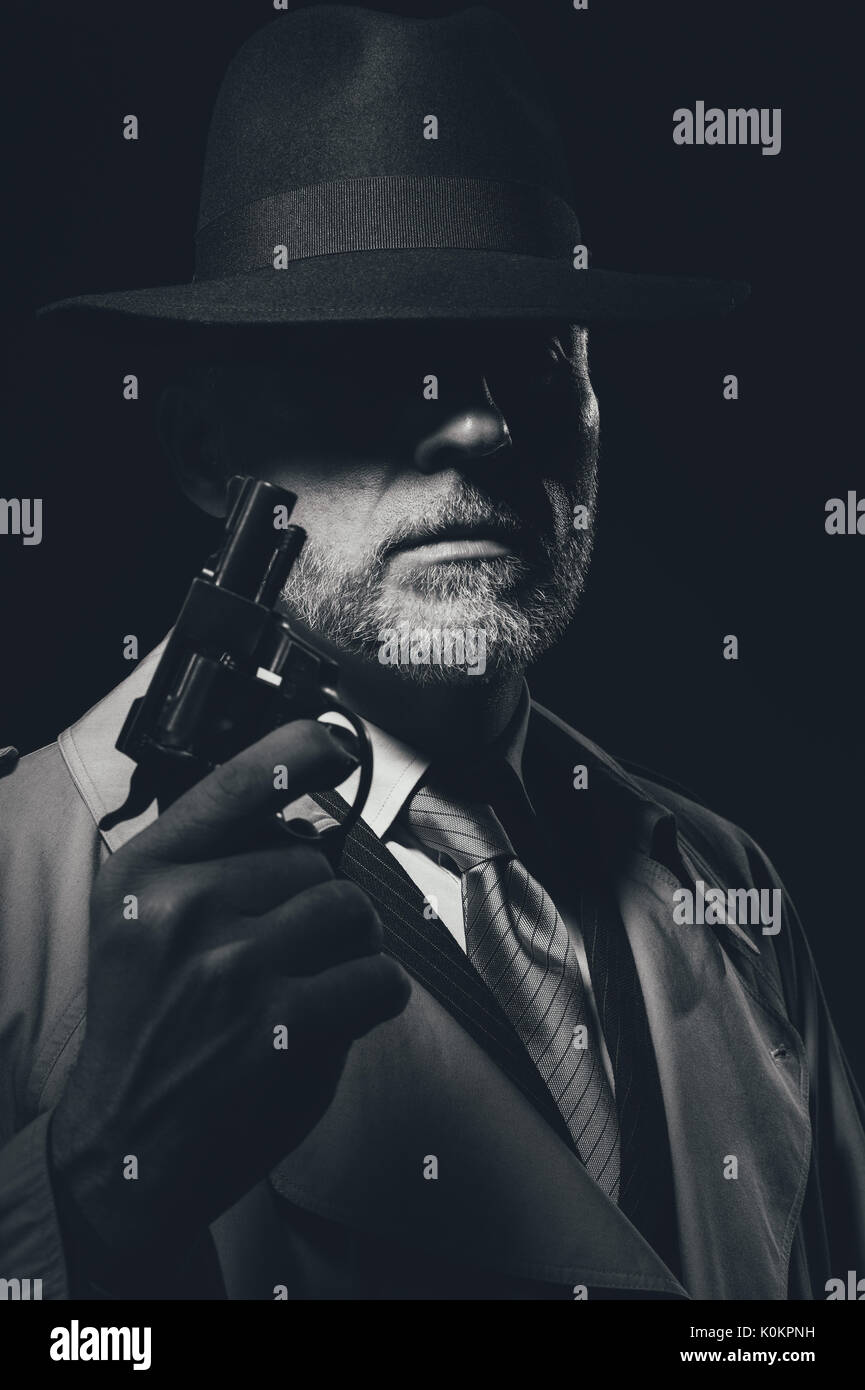 1950s style detective posing in the dark, he is holding a weapon and ...