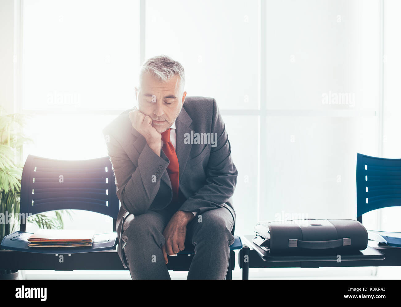 Tired businessman sleeping in the waiting room, he is waiting for a ...