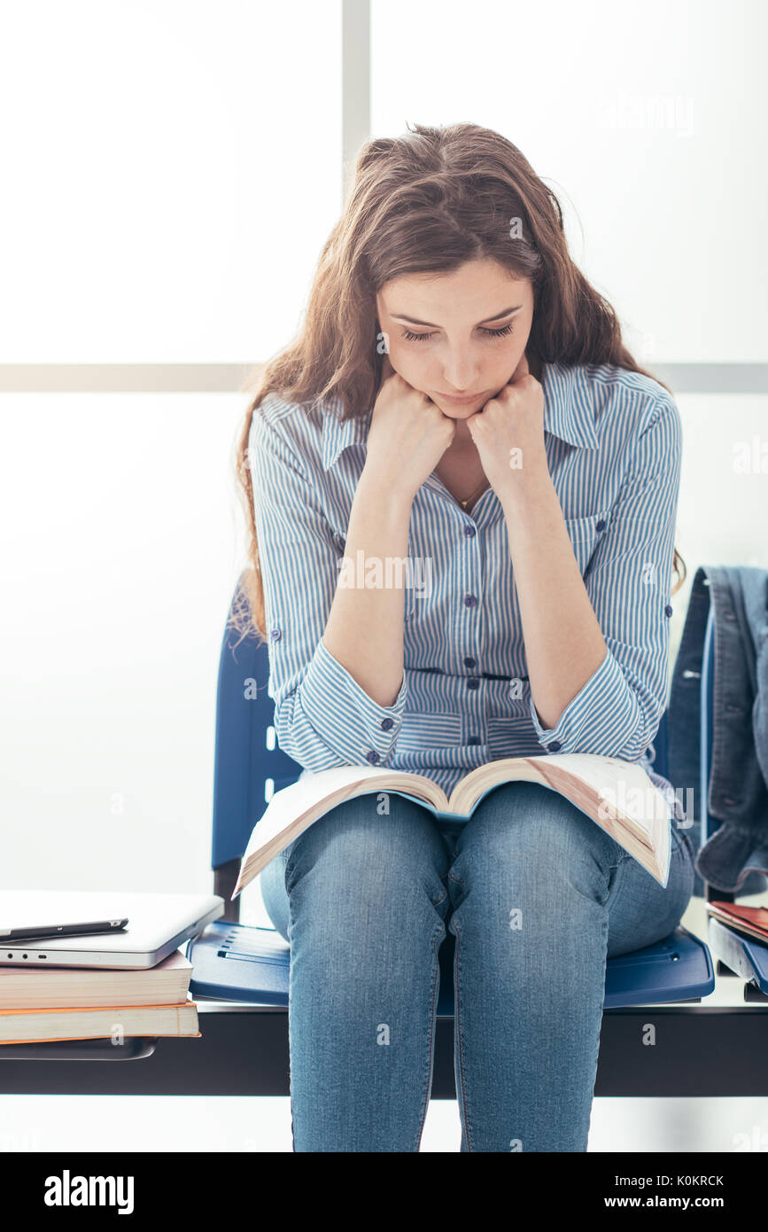 Young college student reviewing before a test in the waiting room, she ...