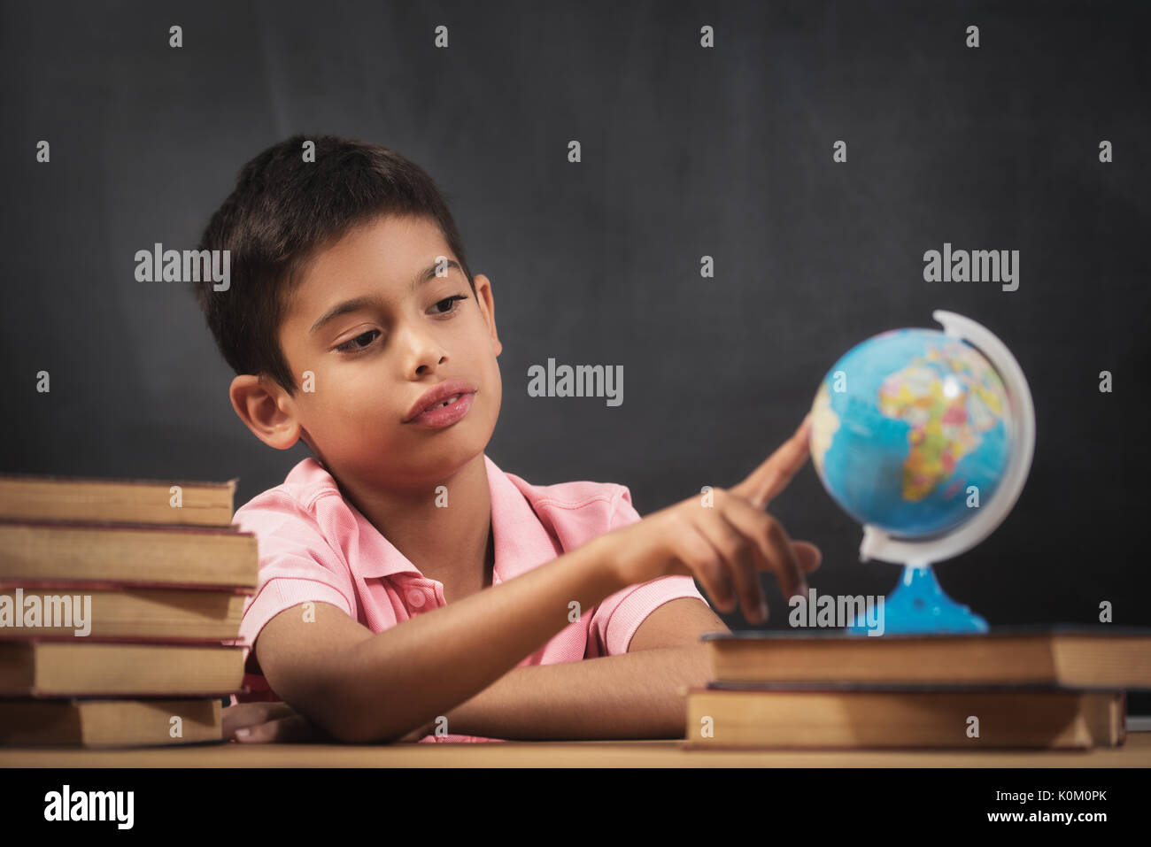 School boy with a globe in classroom.Education concept Stock Photo - Alamy