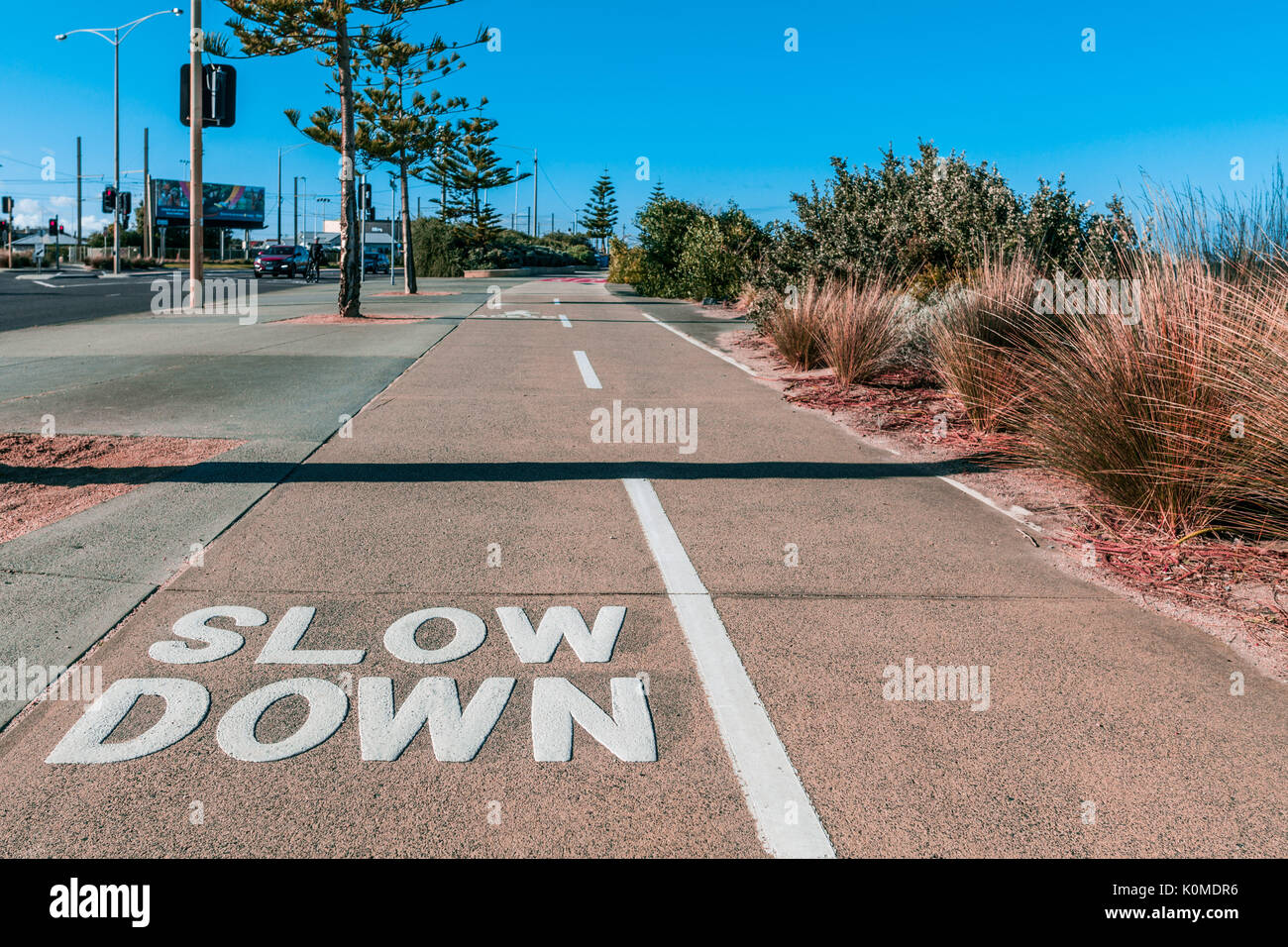 Slow Down sign written on shared footpath for cyclists and pedestrians ...