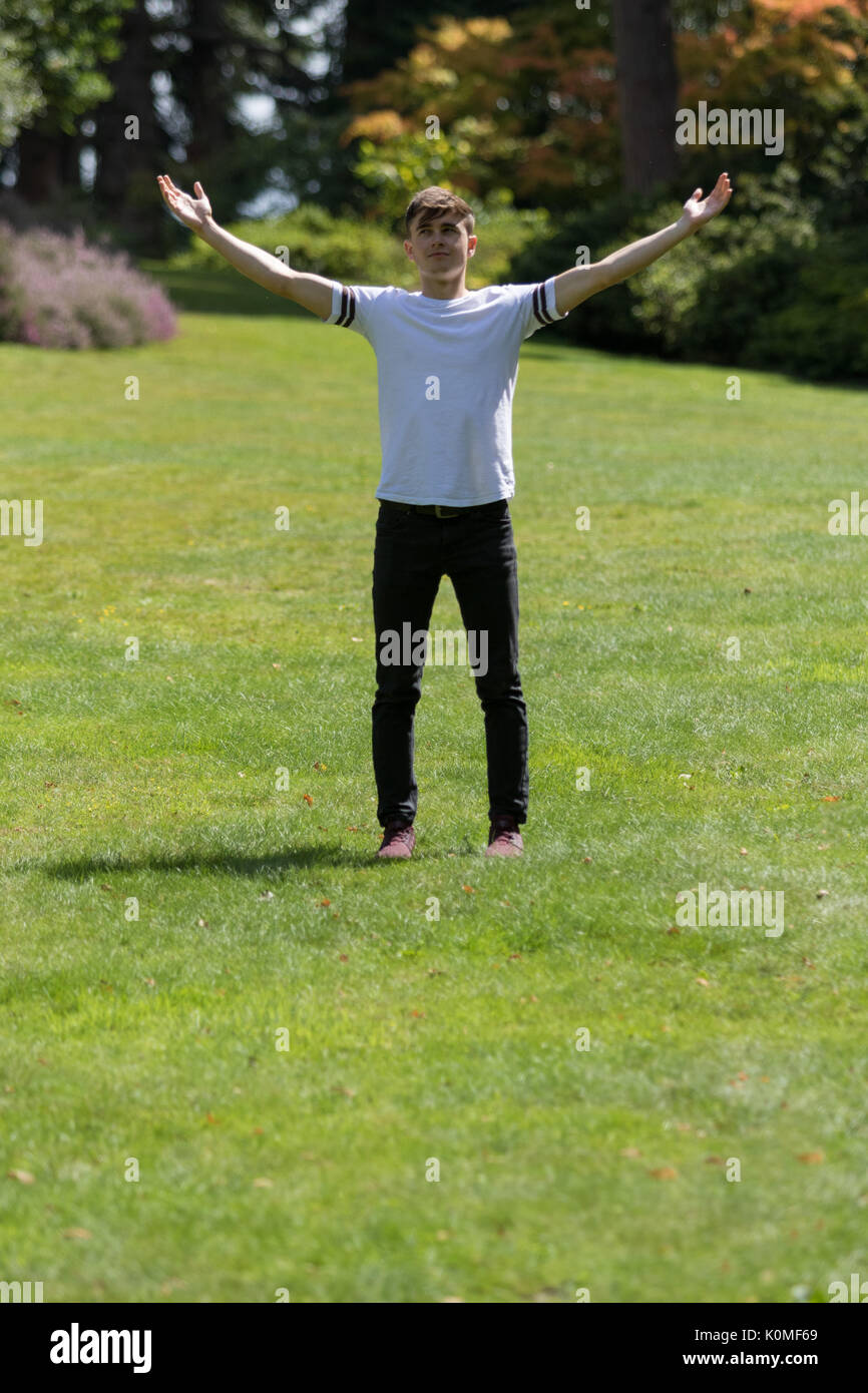 Teenage boy with his arms outstreched on a summer's day Stock Photo - Alamy