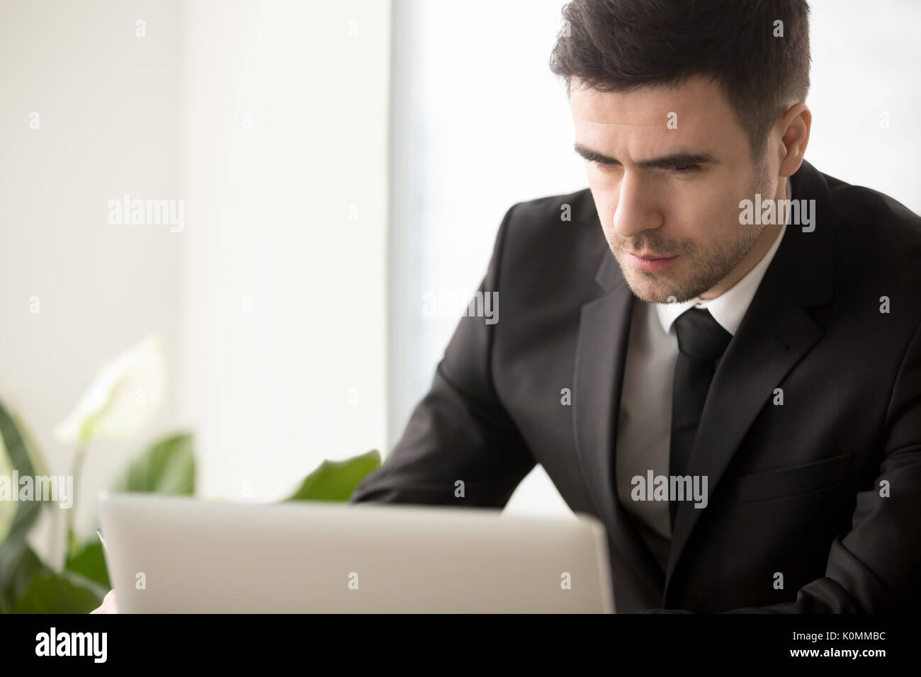 Busy serious businessman focused on working with laptop computer Stock ...