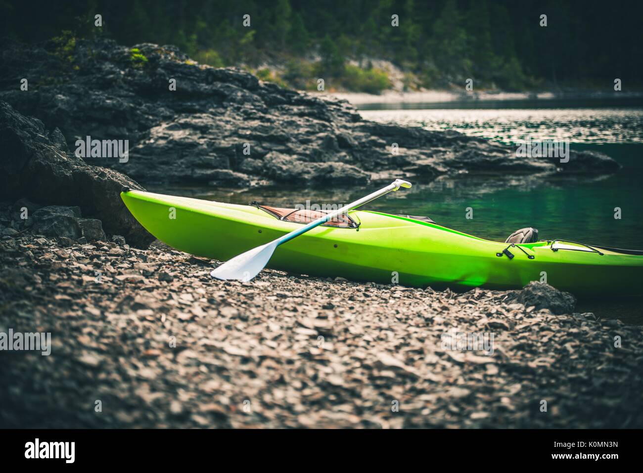 Green Pro Kayak on the Rocky Lake Shore. Kayaking Theme Stock Photo - Alamy