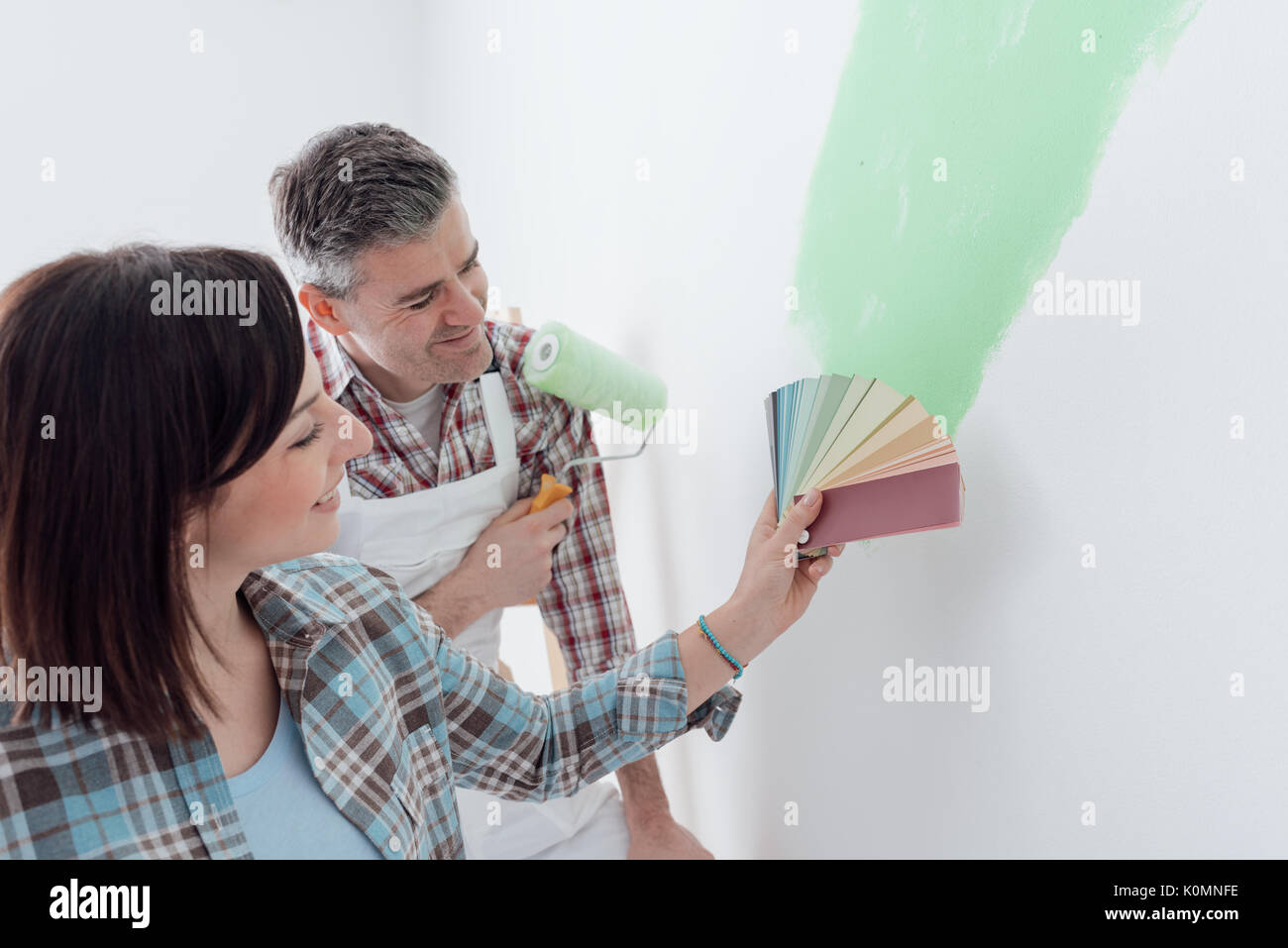 Woman choosing the perfect paint color for her room with a professional ...