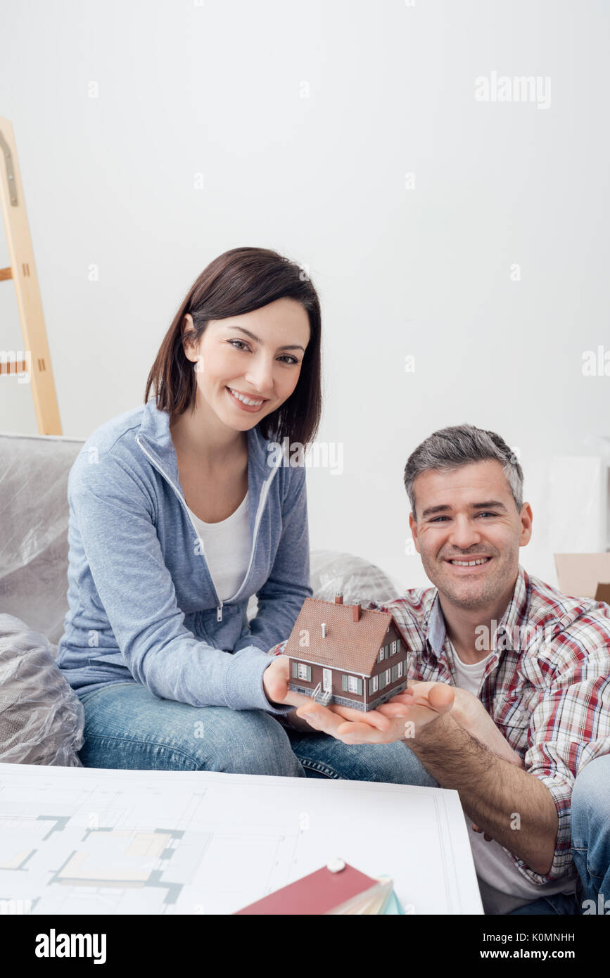 Couple building their dream house: they are holding a model house ...