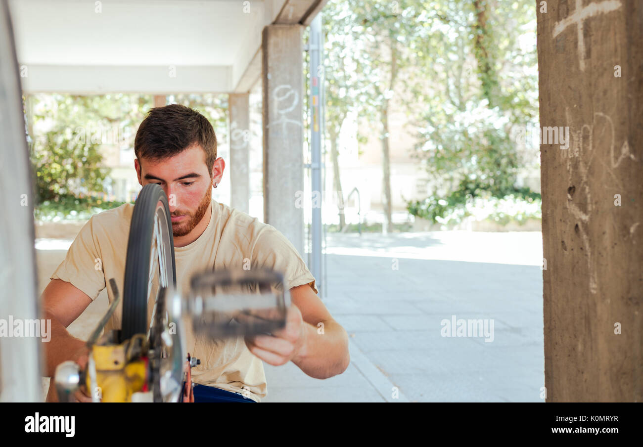 Handsome Man Checking his Bike on the Street Stock Photo - Alamy