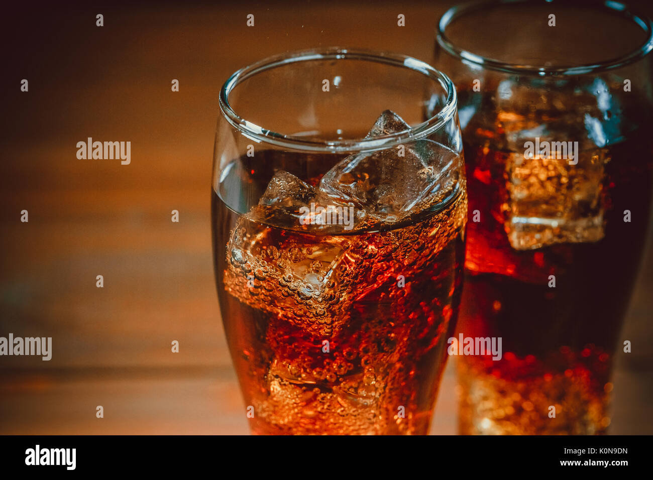 Beautiful cold fizzy cola soda with cubes ice in glasses goblet on old ...