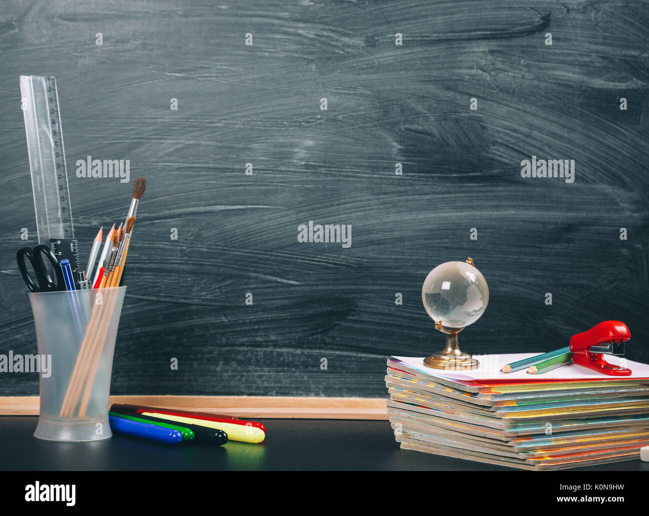 Old blackboard with chalk, books, a globe and a pencil. A beautiful ...
