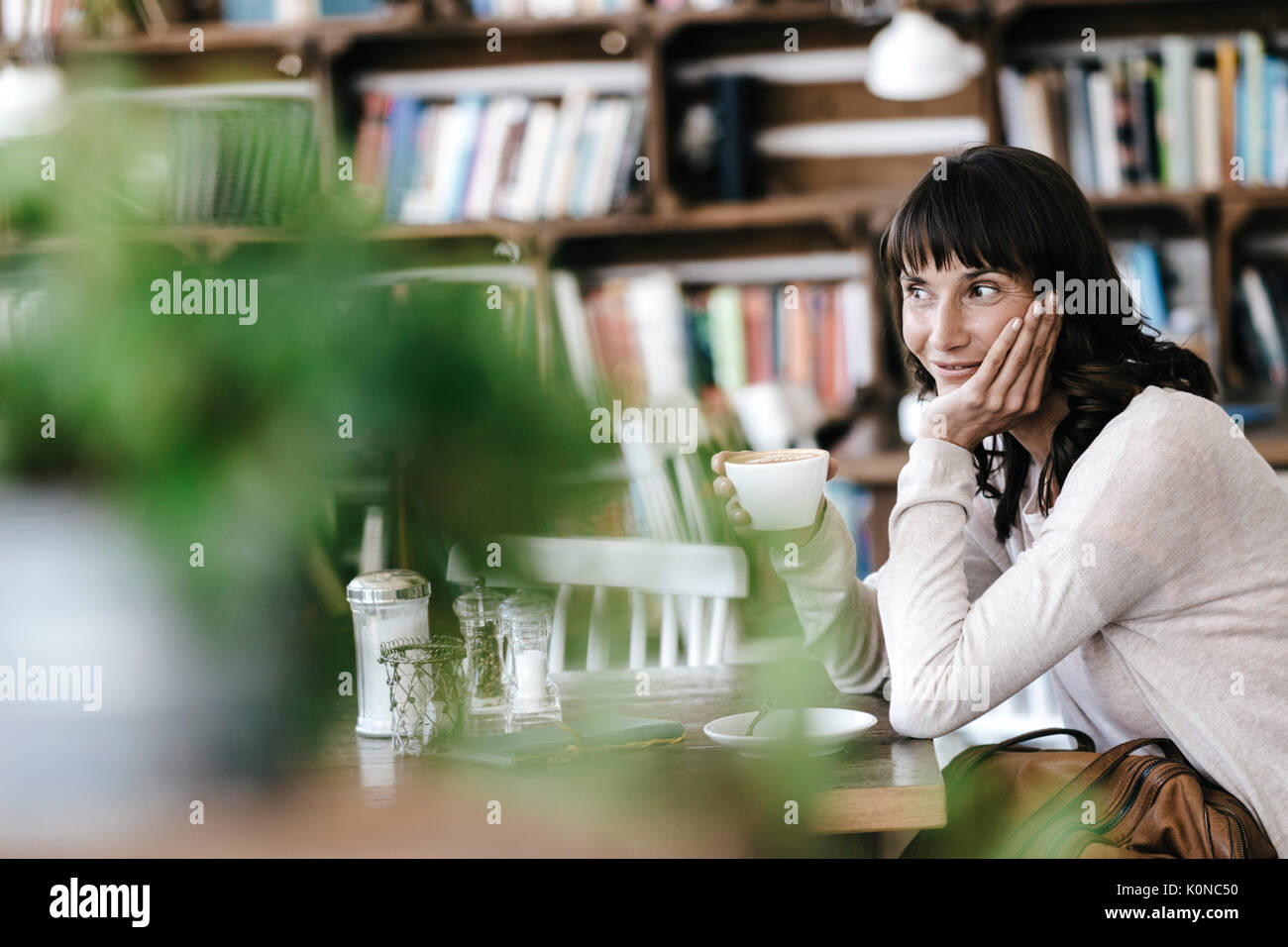 Woman in cafe drinking coffee, daydreaming Stock Photo - Alamy