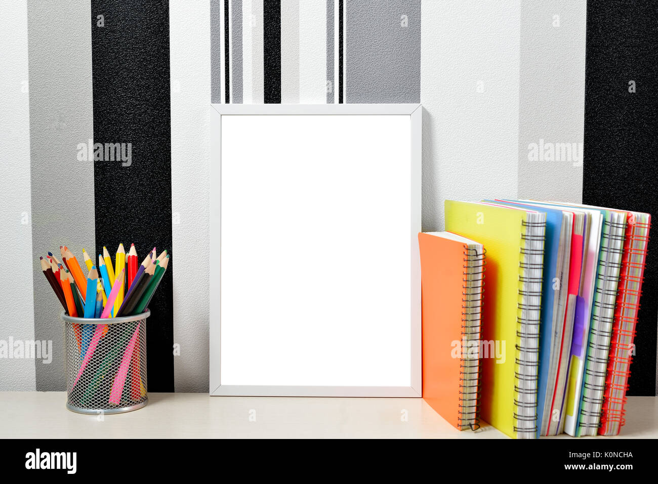 Poster frame mock up template with colored notebooks and can with ...